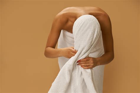 샤워 후 젊은 여자는 베이지 색 배경 위에 고립 된 서있는 동안 흰색 수건으로 그녀의 머리를 닦아 20 24세에 대한 스톡 사진