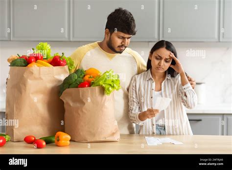Frustrated Indian Couple Checking Bills After Grocery Shopping Stock
