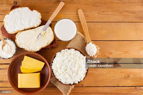 다양한 유제품 우유 코티지 치즈 하드 치즈 사워 크림을 소박한 스타일로 연출합니다 나무 판에 크림 치즈를 곁들인 빵 위쪽 보기