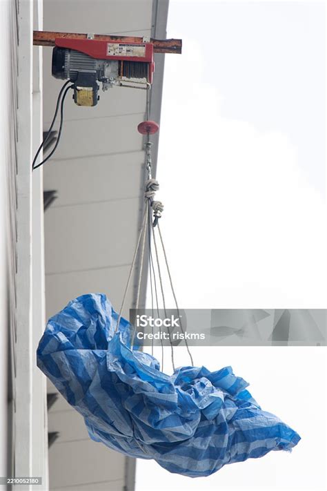 하중이 실린 작은 전기 호이스트 크레인이 콘도미니엄의 발코니에 튀어나와 있습니다 0명에 대한 스톡 사진 및 기타 이미지 0명