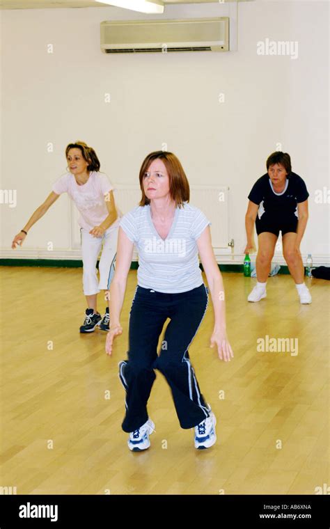 Females Doing Twist Down Exercises In A Workout Class Stock Photo Alamy