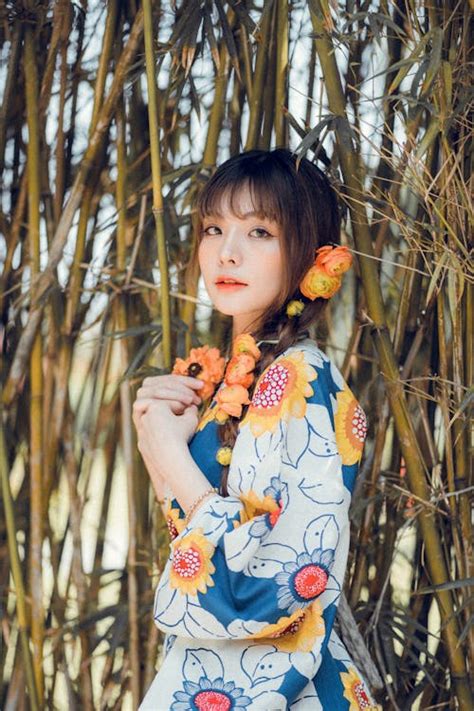 긴 머리 꽃 머리띠 서 있는 수직 쐈어 얼굴 여성 잡고 있는 초상화 패션 사진 포즈를 취하는에 관한 무료 스톡 사진