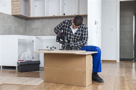 The Carpenter Finalizing The Assembly Of The Kitchen Shelf Stock Image