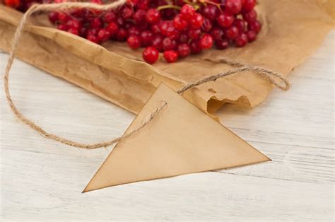 오래 된 낡은 풍 화 흰색 나무 테이블에 구겨진된 종이에 나뭇가지에 신선한 익은 빨간로 완의 움 큼 구멍과의 바탕에 긴 밧줄을 가진 삼각형의 형태로 빈 종이 0명에 대한