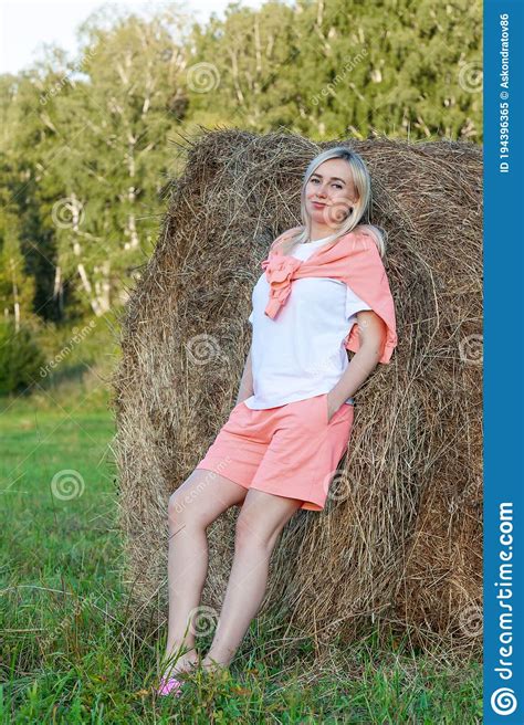 Une Jeune Fille Blonde Se Tient Dans Un T Shirt Blanc Et Un Costume