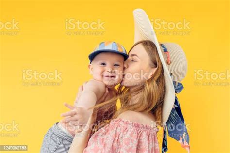 노란 배경에 어린 소년을 들고 여름 모자에 행복한 젊은 어머니 여름 방학 가족에 대한 스톡 사진 및 기타 이미지 가족 귀여운 노랑 Istock