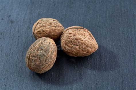 A Stack Of Walnuts Piled Together And Isolated On Dark Background