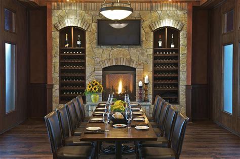 Elegant Wine Built Ins And Stone Fireplace In Dining Room