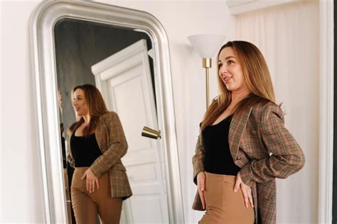 Premium Photo An Adult Woman Looks In The Mirror Preens And Admires