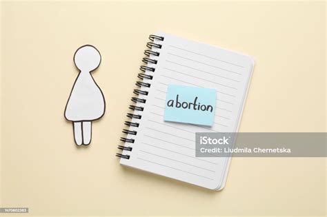 낙태라는 단어가 있는 노트북과 베이지색 배경에 임신한 여성 종이 컷아웃 플랫 레이 0명에 대한 스톡 사진 및 기타 이미지 0