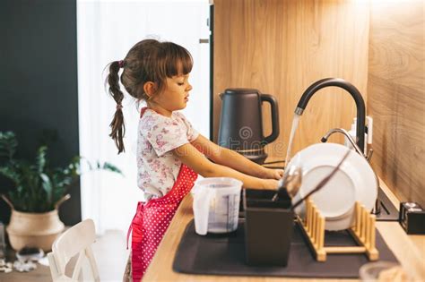 Garotinha Lavando Pratos Com Esponja Na Pia Da Cozinha Em Casa Imagem De Stock Imagem De
