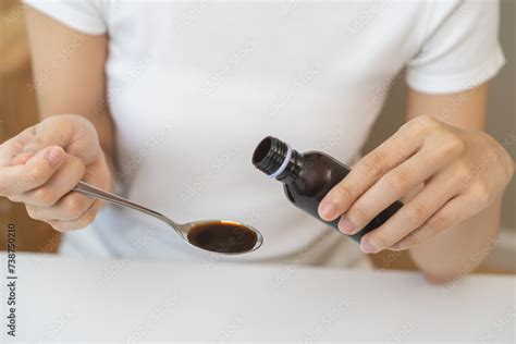 Close Up Hand Of Sick Woman Pouring Syrup Liquid Antipyretic Cough