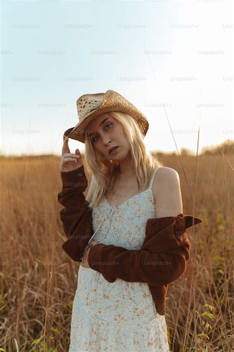 Una Mujer Parada En Un Campo Con Un Sombrero Foto Imagen De Bohemio