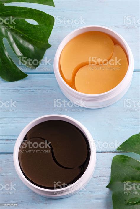 밝은 파란색 나무 배경에 눈 피부 관리를위한 콜라겐 패치의 두 플라스틱 용기 건강관리와 의술에 대한 스톡 사진 및 기타 이미지