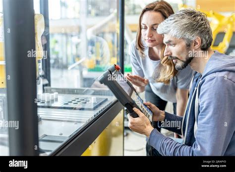 Engineers Testing Industrial Robot In Glass Cabin Stock Photo Alamy