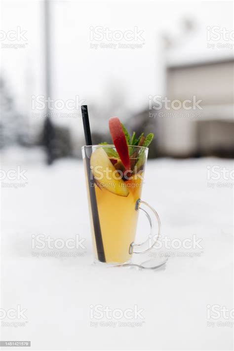 눈 속에서 멀드 와인 유리 머그잔에 담긴 Mulled 와인 오렌지와 사과가 든 뜨거운 적포도주 계피가 든 향신료 유리에