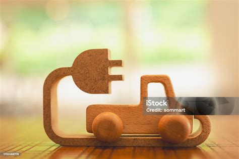 전선과 리튬 배터리가 있는 목조 자동차 연결된 충전 케이블이 있는 기술 배터리 고출력 전기 에너지 깨끗한 전기로 전기 자동차 및 모바일 장치에 배터리 전기 자동차 대체 연료