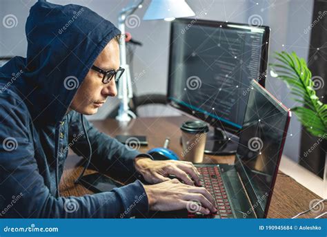 Hacker In The Hood Is Programming Virus Code At The Keyboard For The Laptop Internet Fraud And