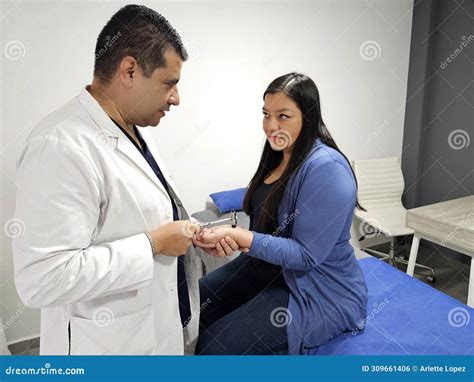 Dark Skinned Male Doctor Attends To Latin Woman Patient Neurological
