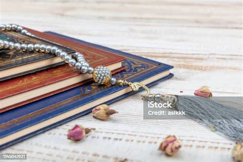 나무 테이블에 걸쳐 알 꾸 란과 Tasbih 또는 묵 주 구슬의 의미 아랍어 서 예와 거룩한 꾸 란 선택적 초점 및 작물 조각