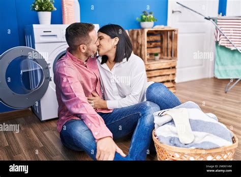Man And Woman Couple Washing Clothes Hugging Each Other And Kissing At
