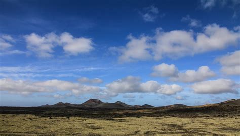 Gray Grass Field Leading To Mountains Under Gray Heavy Clouds · Free