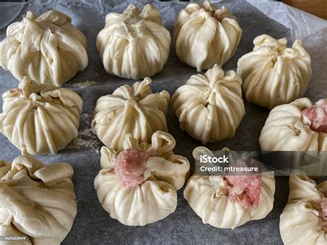 조리되지 않은 Momos 에어 프라이어 팬에서 요리하기 위해 준비된 소시지 고기로 채워진 흰 밀가루와 물 반죽으로 덮인 기름