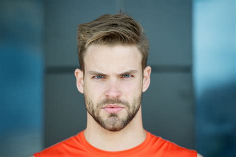 엄격한 얼굴 도시 배경에 강모를 가진 남자 수염이나 면도하지 않은 남자를 가진 남자는 건강한 피부로 잘 생기고 시원해 보입니다 수염을 기고 하 고 외모에 대 한 매력적인