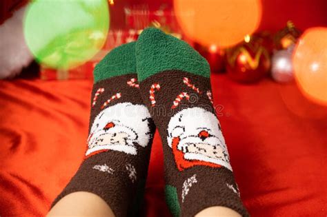 Womenand X27s Feet In Warm Christmas Socks With Santa Claus Close Up