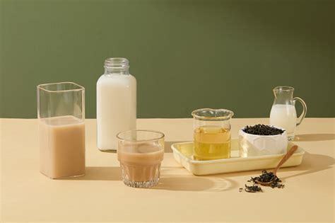 베이지색 테이블 위에 음료가 가득 담긴 몇 개의 유리잔과 컵에 대한 숲의 녹색 배경 문자 메시지 음료 미용 또는 화장품 프레젠테이션을 위한 사진 복사 공간 건강한 생활방식에