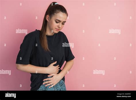 Poor Girl Grabbed Her Stomach On An Isolated Pink Background She