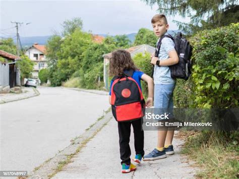 학교로 돌아 가기 배낭을 메고 걷는 행복한 아이들 형제들은 여름 방학을 마치고 학교에 갑니다 남학생과 그의 남동생은 새 학년을 맞이할 준비가 되어 있습니다 2명에 대한 스톡
