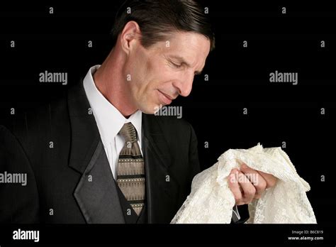 A Grieving Widower Holding His Wife S Dress And Smiling Sadly As He