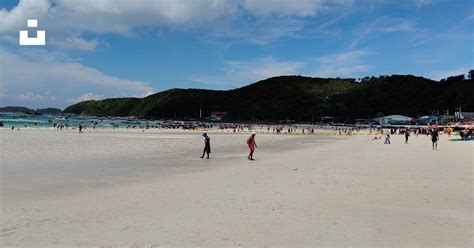 모래 해변을 가로 질러 걷는 한 무리의 사람들 사진 Unsplash의 무료 바닷가 이미지