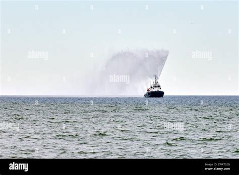 Fireboat Ship Sails On Open Sea Directing Jets Of Water To Sides