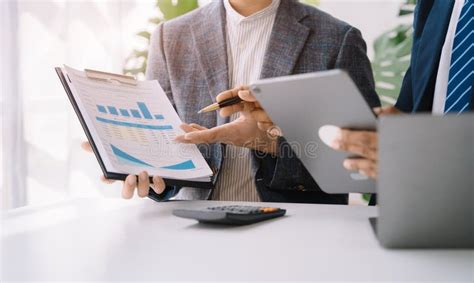 Businessmen Team Or Financial Data Analysts Working With Tablets And Laptop Computers And Data