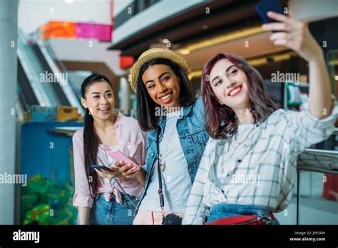Smiling Young Women Taking Selfie In Shopping Mall Young Girls