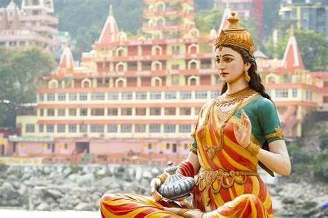 갠지스 강 강둑에 앉아있는 여신 Parvati 동상의 멋진 전망 배경에 흐린 Trimbakeshwar 사원 리 시 케시