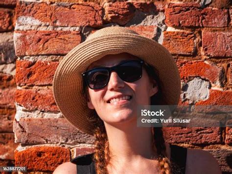 Wanita Muda Dengan Potret Topi Jerami Di Dinding Bata Merah Latar