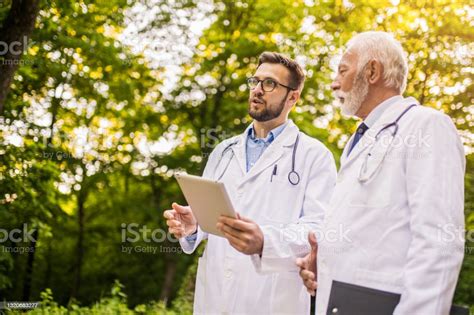 Two Doctors Working In Nature Stock Photo - Download Image Now - Active ...
