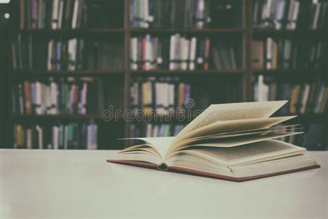 Закройте вверх открытых книги и стога книг на столе с винтажной