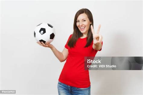 매력적인 유럽 젊은 여자 축구 팬 또는 빨간색 유니폼 선수 웃는 축구공을 잡고 흰색 배경에 고립 승리 기호 스포츠 놀이 축구 응원 건강 한 라이프 스타일 개념 2018년에