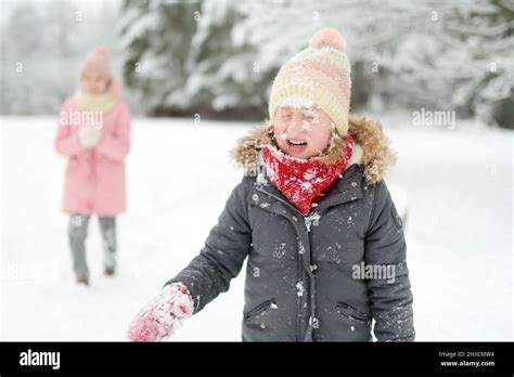 Two Adorable Young Girls Having Fun Together In Beautiful Winter Park