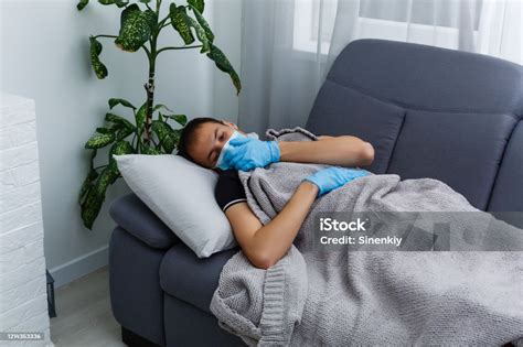 상부 호흡기를 보호하기 위해 의료 용 얼굴 마스크를 착용 하는 파란색 장갑을 가진 손 사람의 손은 바이러스 및 감염 질병에 대한