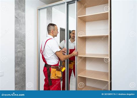 Furniture Assembling Professional Worker Installing Wardrobe At Living