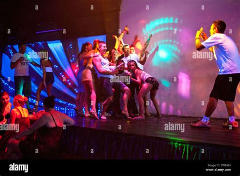 Young People Tourists Backpackers Pose To A Photo In A Nightclub At
