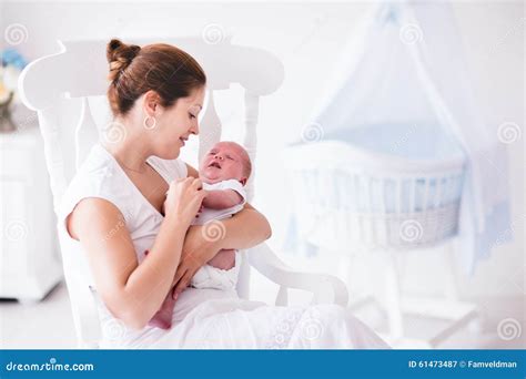Мать и Newborn младенец в белом питомнике Стоковое Изображение