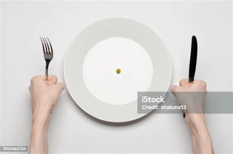 건강 한 음식 테마 손에 들고 칼과 흰색 테이블 상단 보기에 녹색 완두콩과 접시에 포크 건강한 식생활에 대한 스톡 사진 및 기타