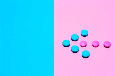 파란색과 분홍색 정제는 복사 공간이 있는 파란색과 분홍색의 종이 배경에 화살표의 형태로 배치 0명에 대한 스톡 사진 및 기타