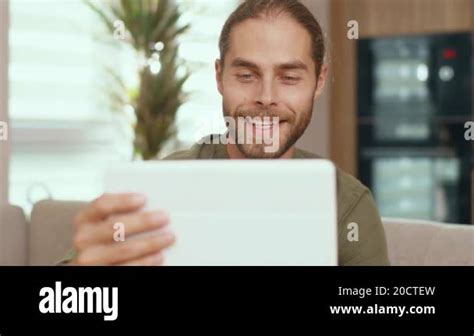 Happy Young Caucasian Man Hipster Videochatting Holding Tablet Computer Talking To Girlfriend